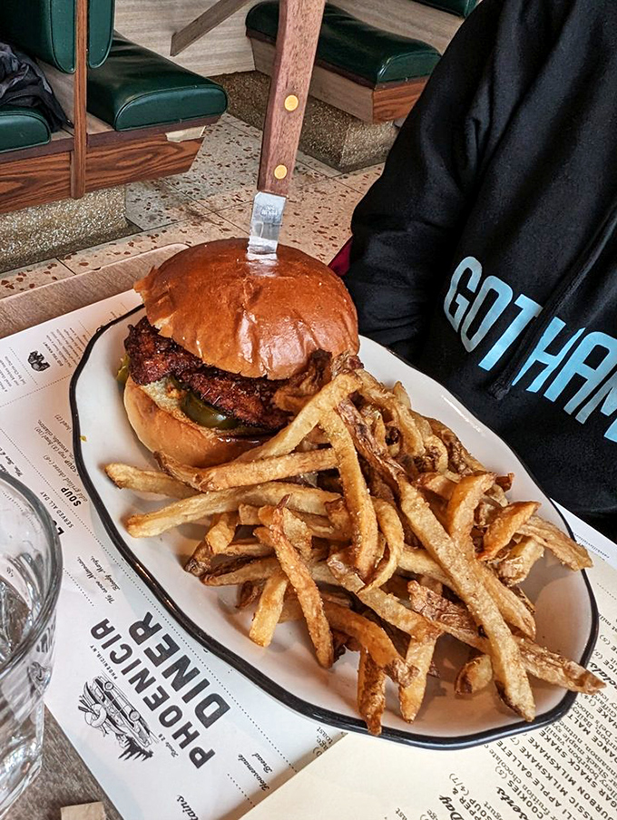 A burger that requires both hands and a strategy. Those hand-cut fries aren't sidekicks—they're co-stars in this plate of comfort food perfection.