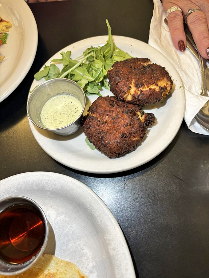 These crab cakes aren't just fried—they're bronzed to perfection. That little cup of sauce is about to become your new best friend.