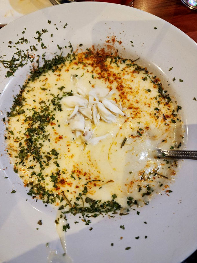 Cream of crab soup so rich it could apply for a mortgage, topped with enough fresh herbs to make your garden jealous.