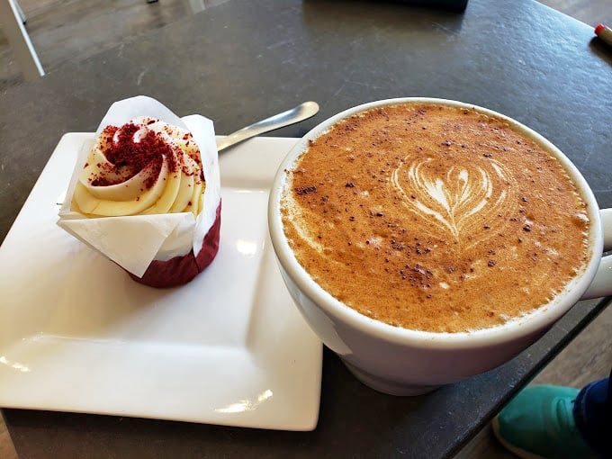 Red velvet cupcake with a swirl of cream cheese frosting paired with artisanal coffee &ndash; proof that adulthood has its privileges.
