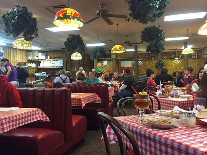 A bustling dining room where families gather under colorful Tiffany-style lamps to participate in the time-honored tradition of carb-loading together.