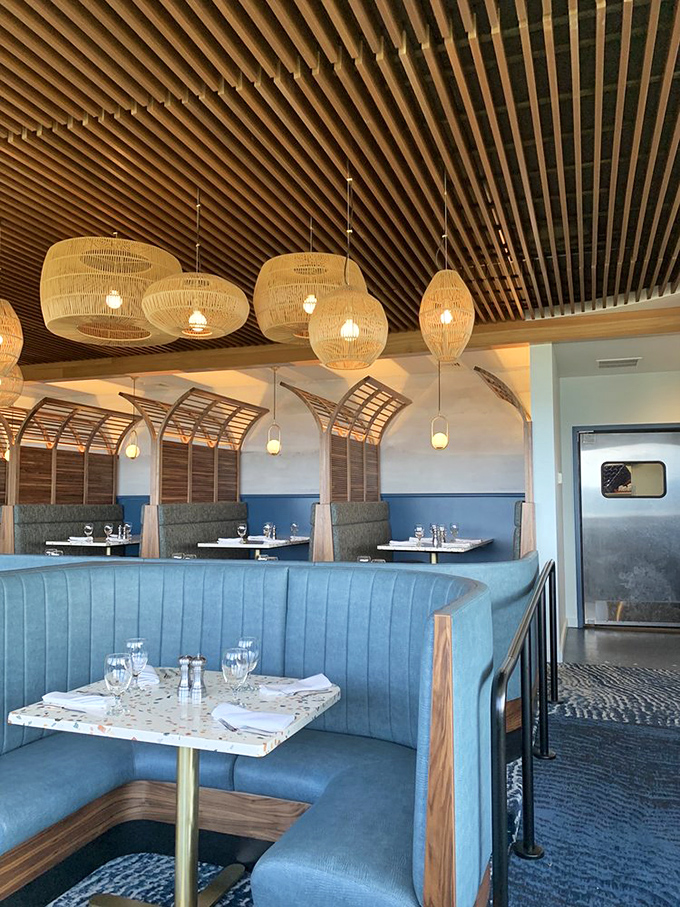 Coastal-chic booths invite intimate conversations while woven pendant lights create the ambiance of a sunset beach gathering.