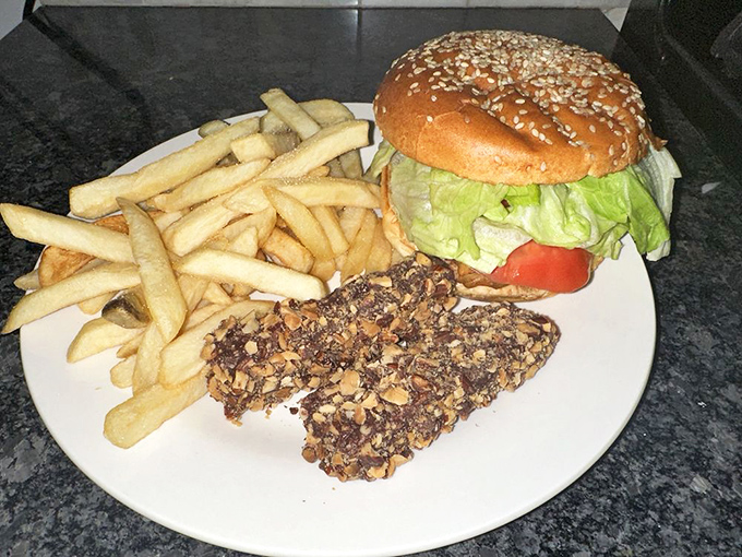 A burger that doesn't need to show off, flanked by golden fries and what appears to be a chocolate-dipped treat for dessert.