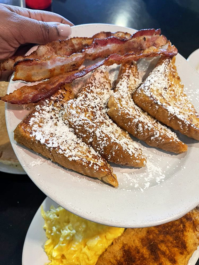 French toast dusted with powdered sugar and served with bacon&mdash;because every sweet moment deserves a savory counterpoint.