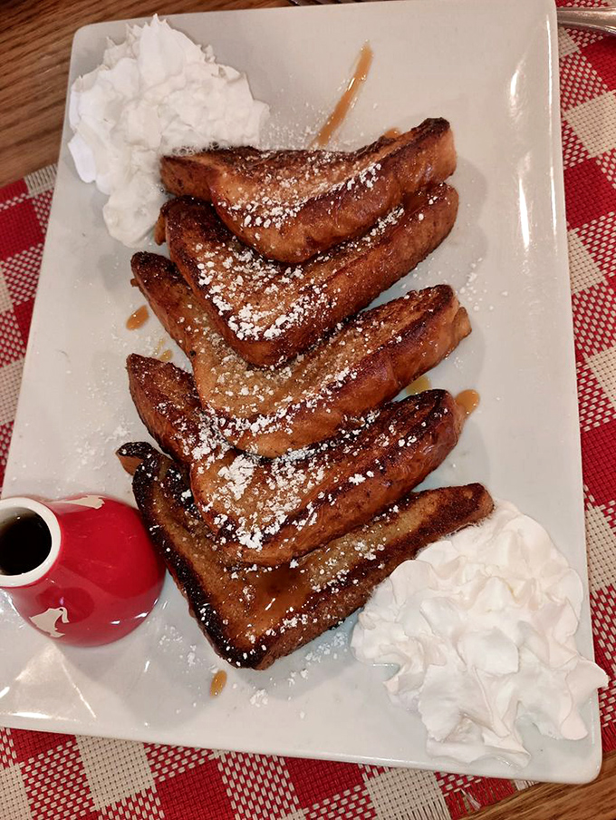 French toast that's dressed for success with powdered sugar and whipped cream. The maple syrup in that little pitcher is about to make everyone very happy.