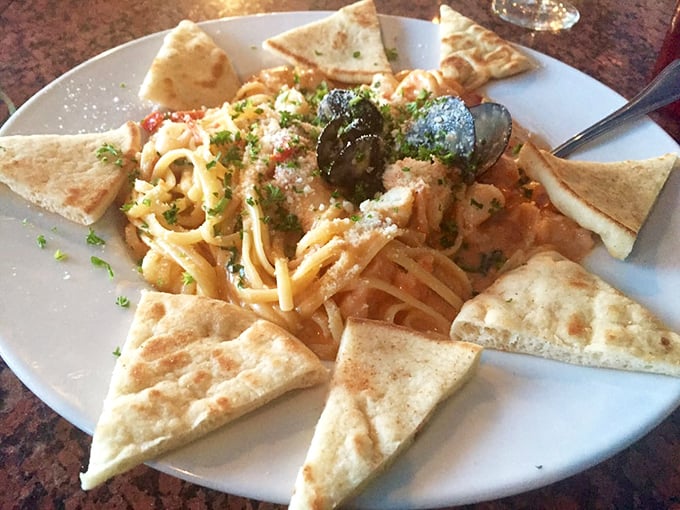 Pasta meets Mediterranean in this seafood symphony. Those triangles of pita standing guard around the plate are not just for show.