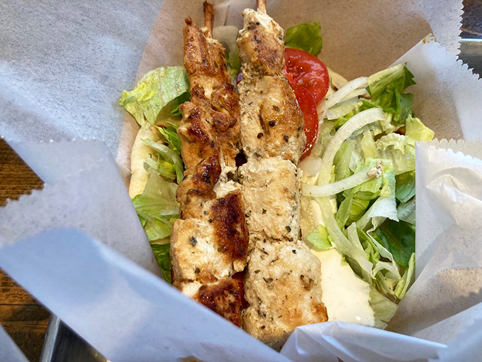 Grilled chicken skewers nestled in a pita with fresh veggies&mdash;proof that not all heroes wear capes, some wear marinade.