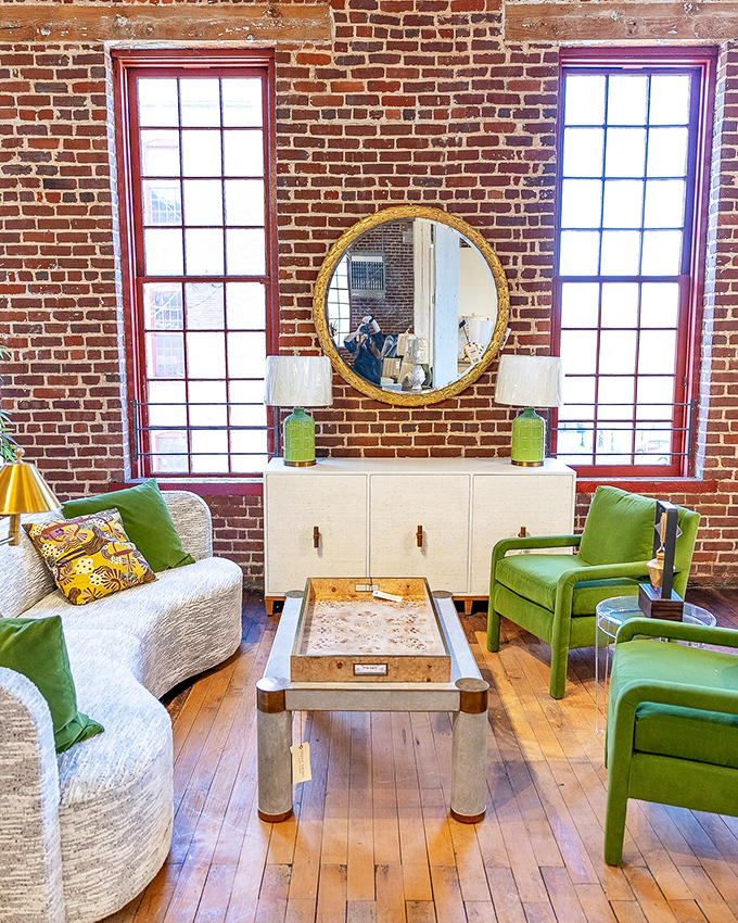 Exposed brick and vibrant green chairs create a mid-century modern oasis that would make Don Draper nod approvingly while mixing an Old Fashioned.