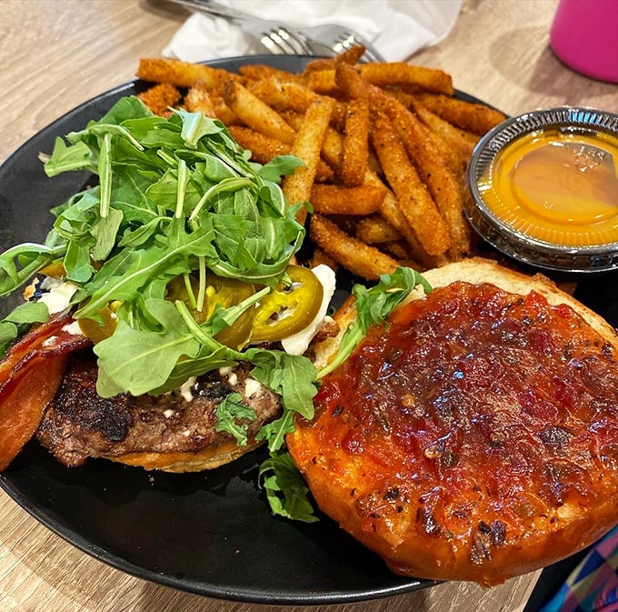 A burger that requires both hands, several napkins, and possibly a post-meal nap – the holy trinity of proper comfort food.