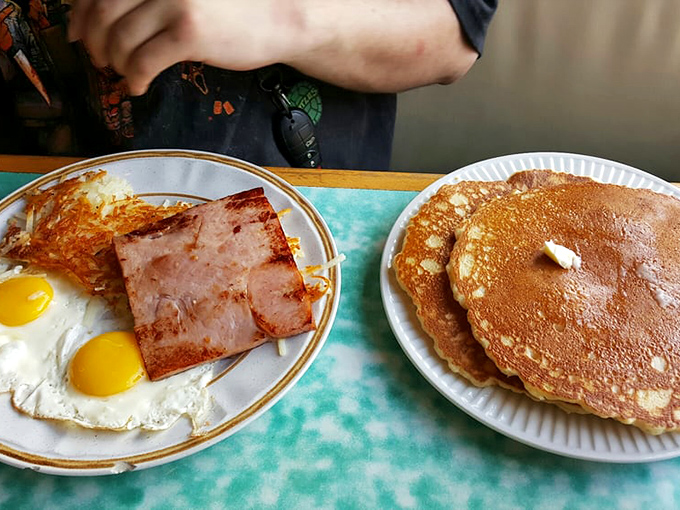 Pancakes so perfectly golden they belong in Fort Knox, paired with ham and hash browns. The breakfast trifecta of champions.
