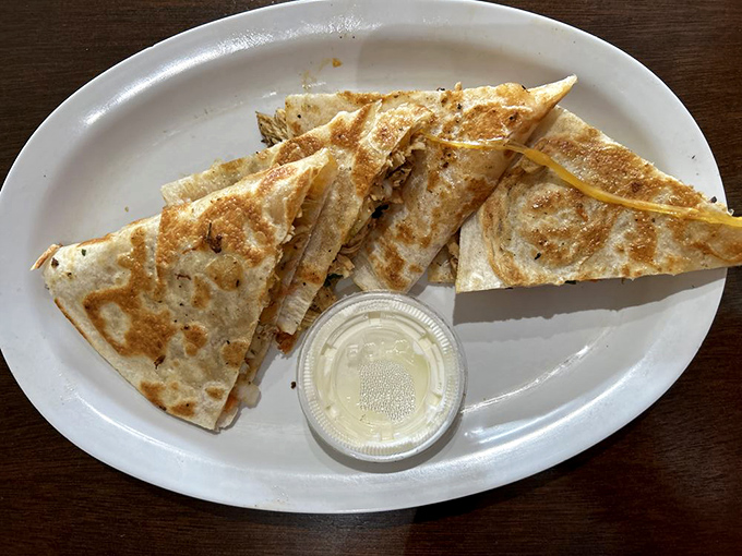 The quesadilla – that perfect marriage of melted cheese and tortilla – achieving golden-brown perfection that makes you remember why classics became classics.