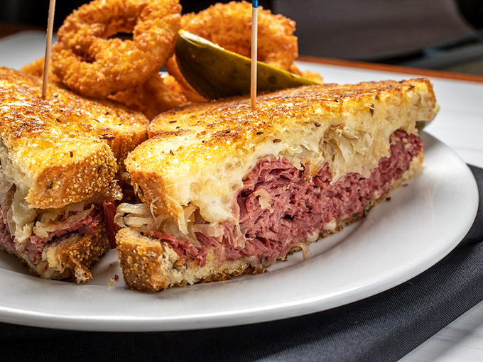 The Reuben sandwich stands tall and proud, layers of corned beef and sauerkraut creating a masterpiece that demands two hands.