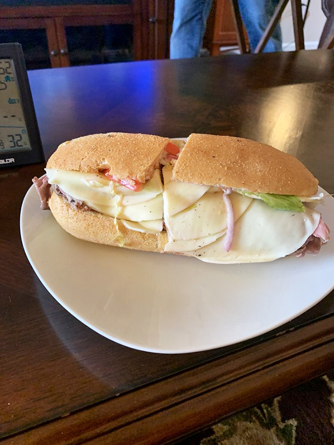 Layers upon layers of thinly sliced meats and cheese create a sandwich skyscraper that demands both admiration and a hearty appetite.