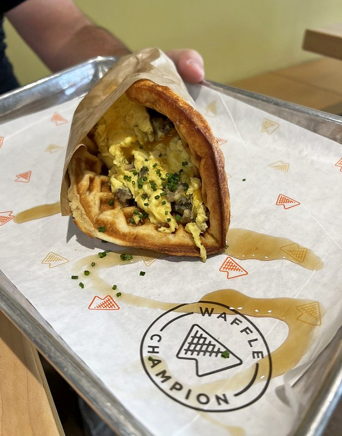 Breakfast's greatest hits album: eggs, cheese, and sausage nestled in a golden waffle embrace.