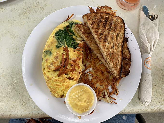 An omelet that's having an identity crisis as a gourmet dinner&mdash;topped with what appears to be grits and hot sauce swirls.