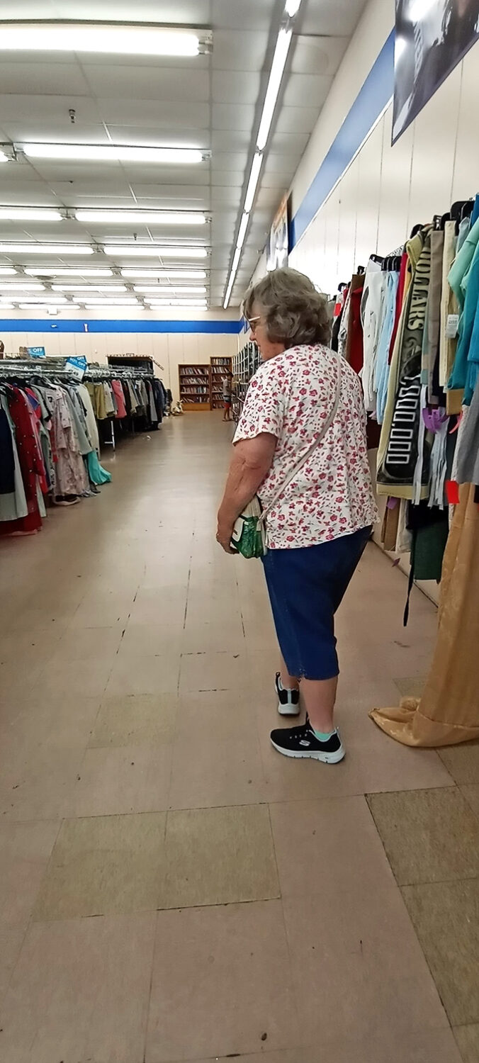 Every serious thrifter knows the art of the browse&mdash;this shopper demonstrates perfect form while scanning for that special something among the hanging possibilities.