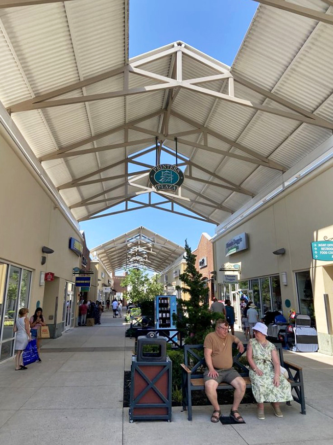 Beneath the covered walkways, shoppers move with purpose while some pause to rest&mdash;the universal language of outlet shopping in full display.