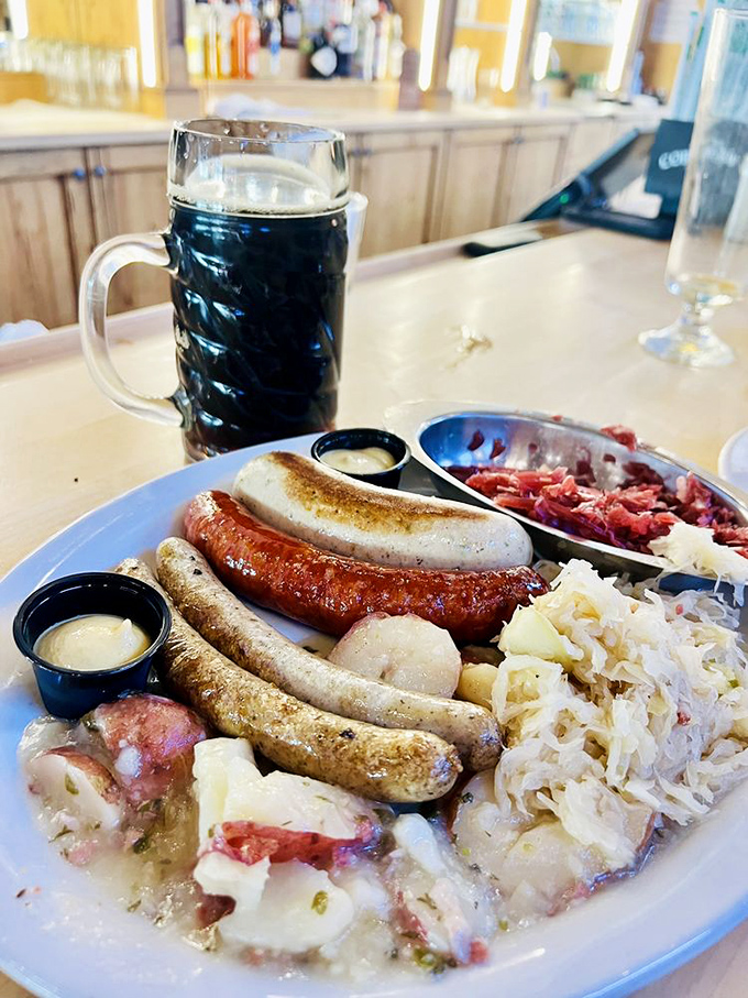 A symphony of sausages accompanied by sauerkraut and a dark beer standing at attention. This plate has more German heritage than my ancestry test results.