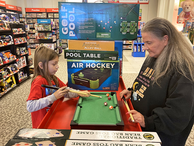 Multigenerational fun breaks out spontaneously as a mini pool tournament reminds shoppers that outlets aren't just about clothes.