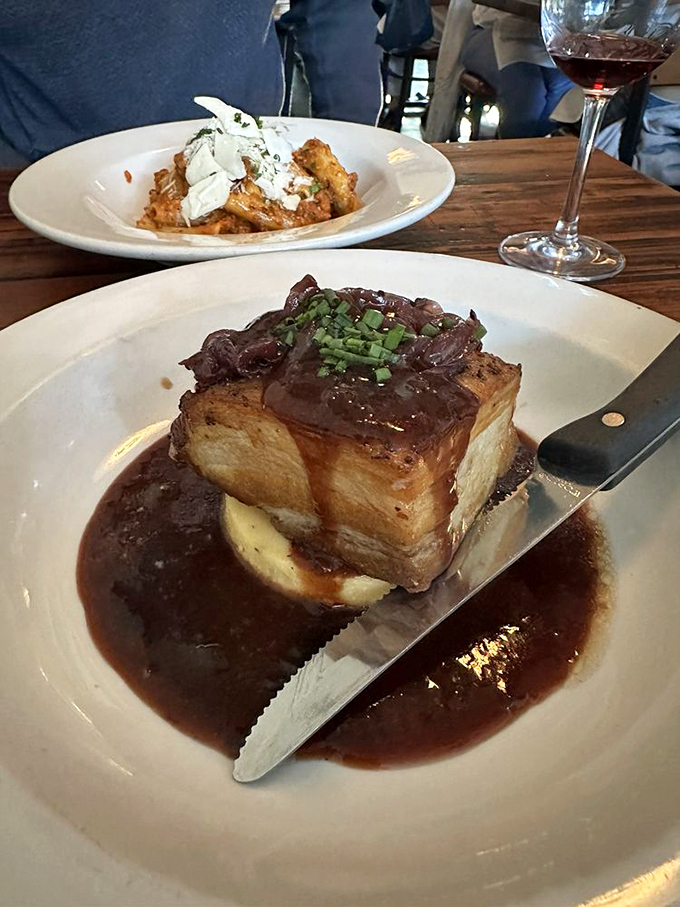 This pork belly isn't just dinner&mdash;it's architecture. A perfect cube of succulence perched atop mashed potatoes, swimming in a sauce worth bottling.