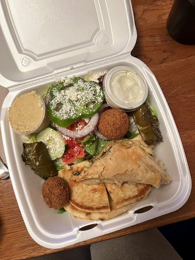A vegetarian feast that proves meatless doesn't mean joyless – dolmades, spanakopita, and falafel creating harmony in a takeout container.
