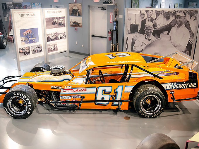 The bright orange #61 modified racer gleams under museum lights, its open-wheel design a reminder of racing's raw, no-frills origins.