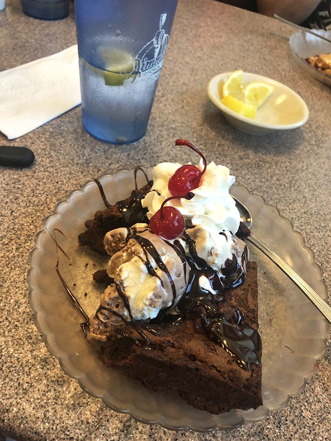 This brownie sundae isn't dessert &ndash; it's therapy. Hot fudge cascading over ice cream with cherries standing guard like sweet sentinels.