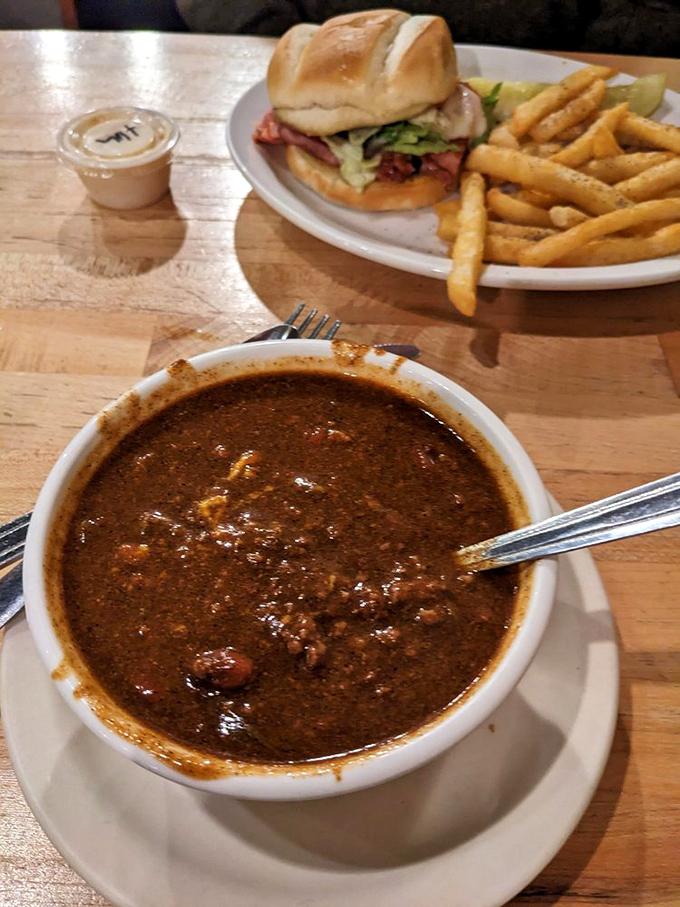 This isn't just chili&mdash;it's a bowl of slow-simmered conviction that cold Michigan days were made for warm, hearty meals. The sandwich in the background is just waiting its turn.