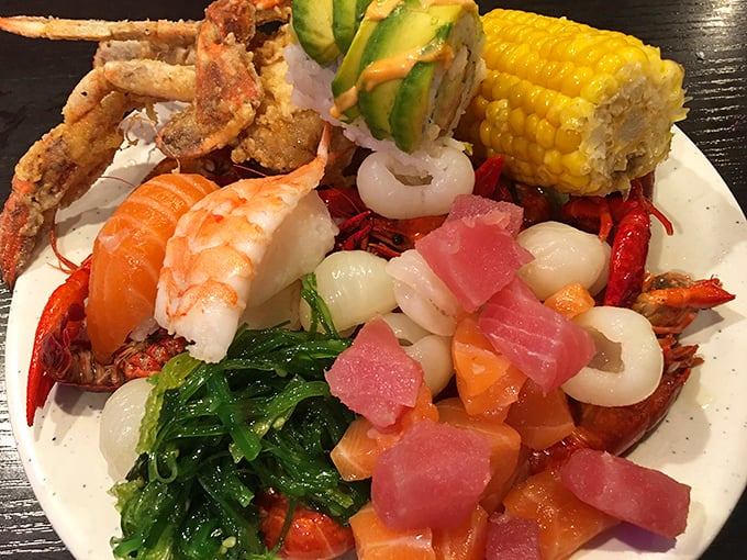 The ultimate seafood sampler plate &ndash; crab, corn, sashimi, and more sharing space in delicious harmony. This isn't a meal; it's an expedition across culinary continents.