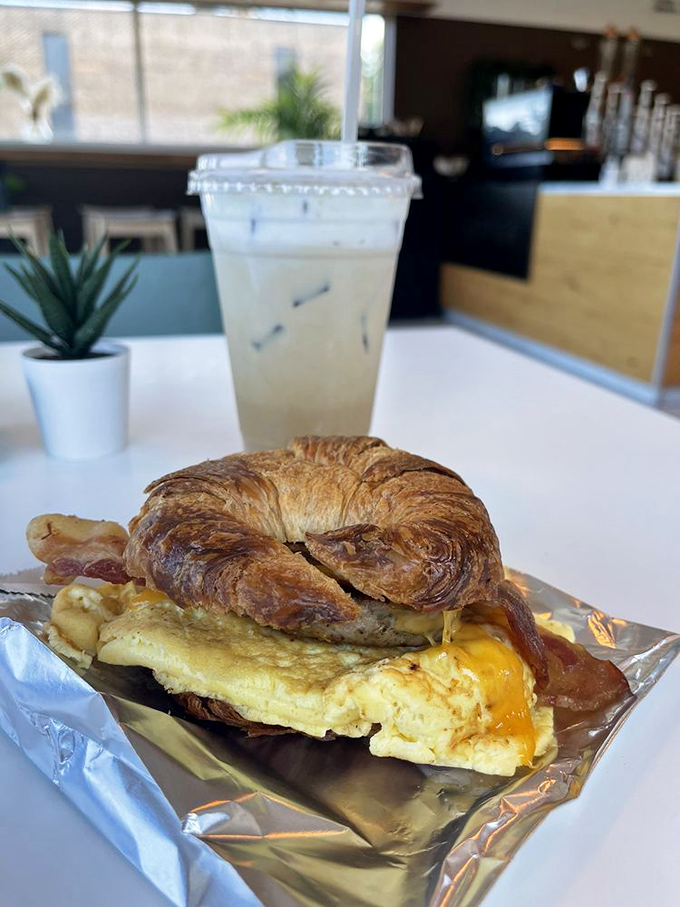 Breakfast architecture at its finest&mdash;a golden-hued croissant cradling eggs and cheese in a symphony of morning perfection.