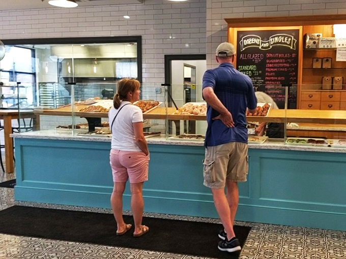 The universal language of donut selection: pointing, contemplating, and the occasional gasp of delight when spotting your favorite.