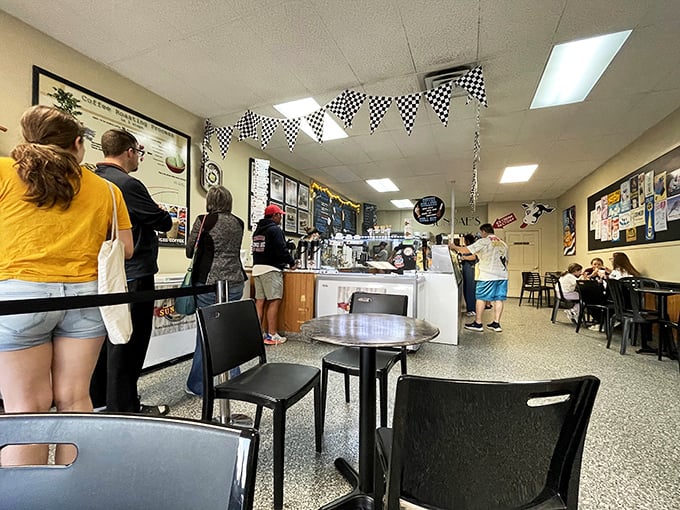 The line forms not because of slow service but because some pleasures are worth waiting for. Veterans teach first-timers the proper protocol of flavor selection.