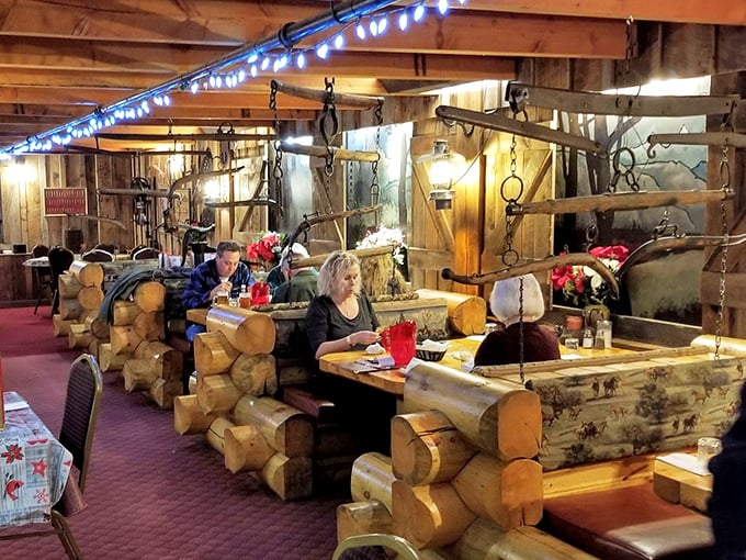 Log cabin-style booths create intimate dining spaces within the larger room. Here, conversations flow as freely as the drinks and laughter.