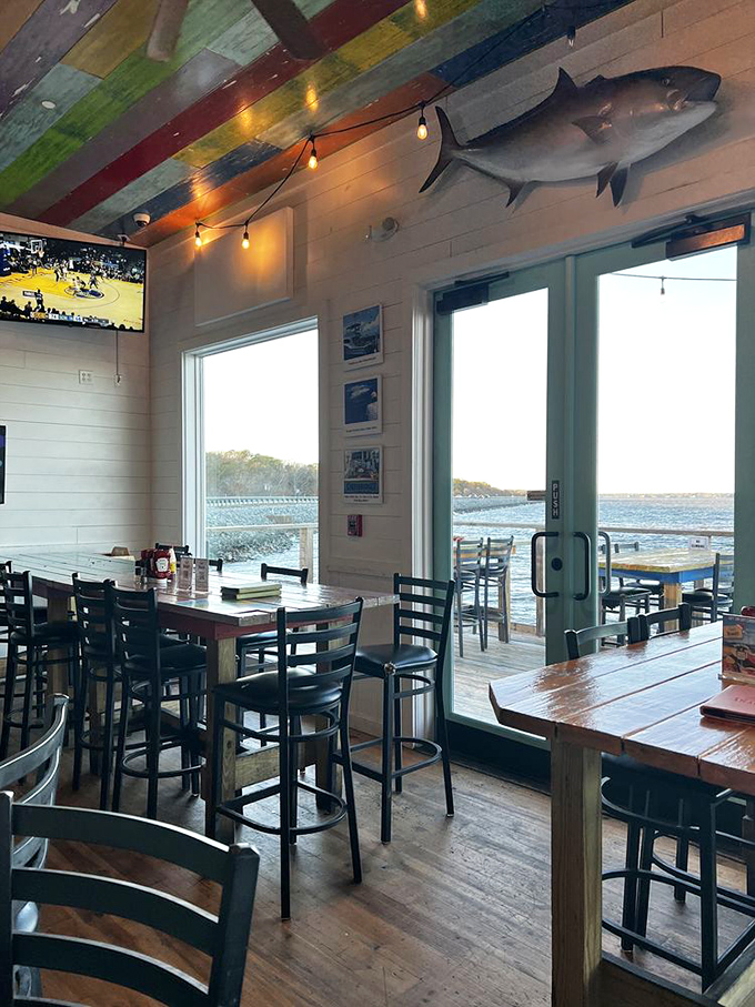Windows framing water views and a mounted fish keeping watch&mdash;this dining room feels like the perfect blend of comfort and coastal adventure.