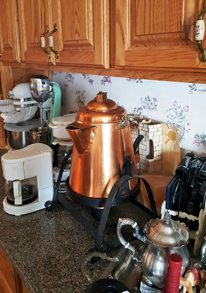 Morning coffee brewed in this copper pot tastes better by royal decree. The kitchen combines practical modern appliances with touches of vintage charm.