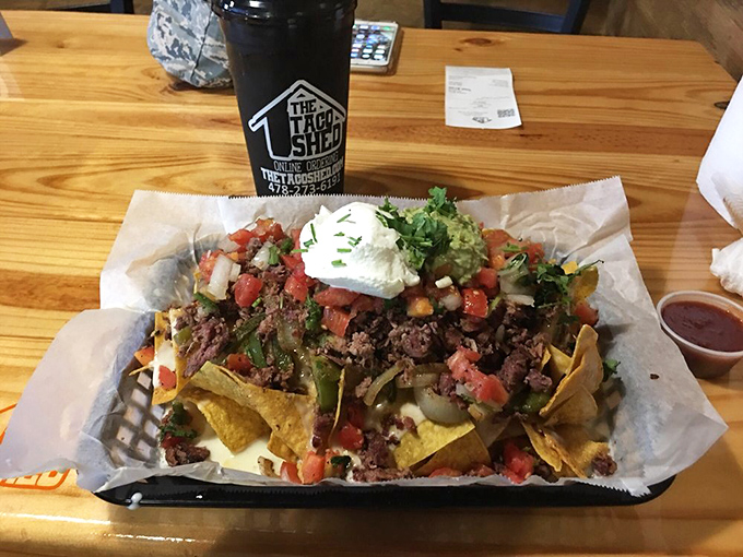 Nachos so loaded they need their own ZIP code. When architecture meets appetite, beautiful things happen on a wooden table.