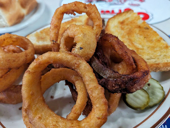 Onion rings that deserve their own fan club. Crispy, golden halos that make you wonder why anyone bothers with lesser side dishes.