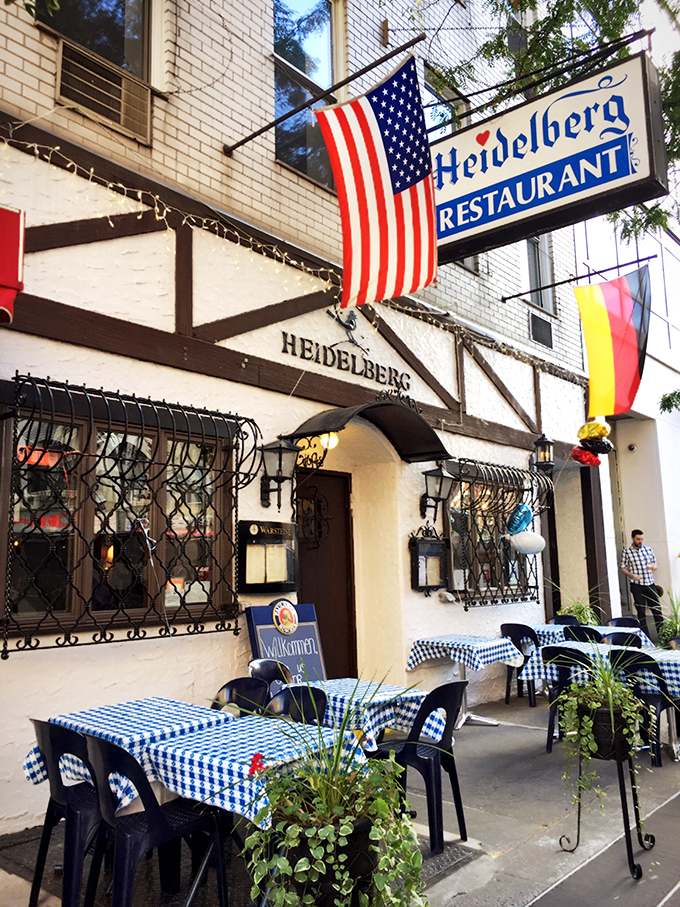 Outdoor seating with classic blue-and-white checked tablecloths&mdash;where Manhattan briefly becomes Munich on a sunny afternoon.