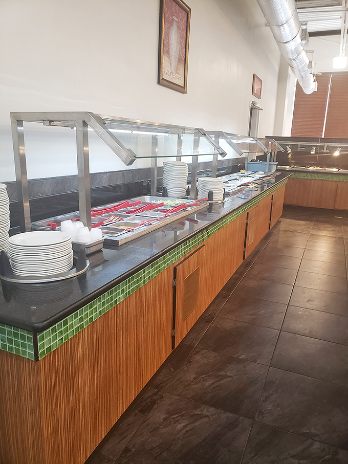 Clean plates await their destiny at the buffet line, each one a blank canvas for your personal masterpiece of culinary excess.