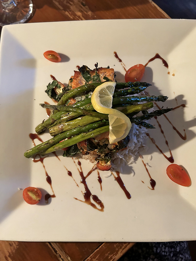 Salmon and asparagus arranged with such precision that for a moment you consider framing it instead of eating it. The moment passes quickly.