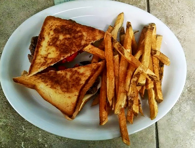 The classic club sandwich – where layers of goodness come together like a delicious architectural achievement, surrounded by perfectly crisp fries.