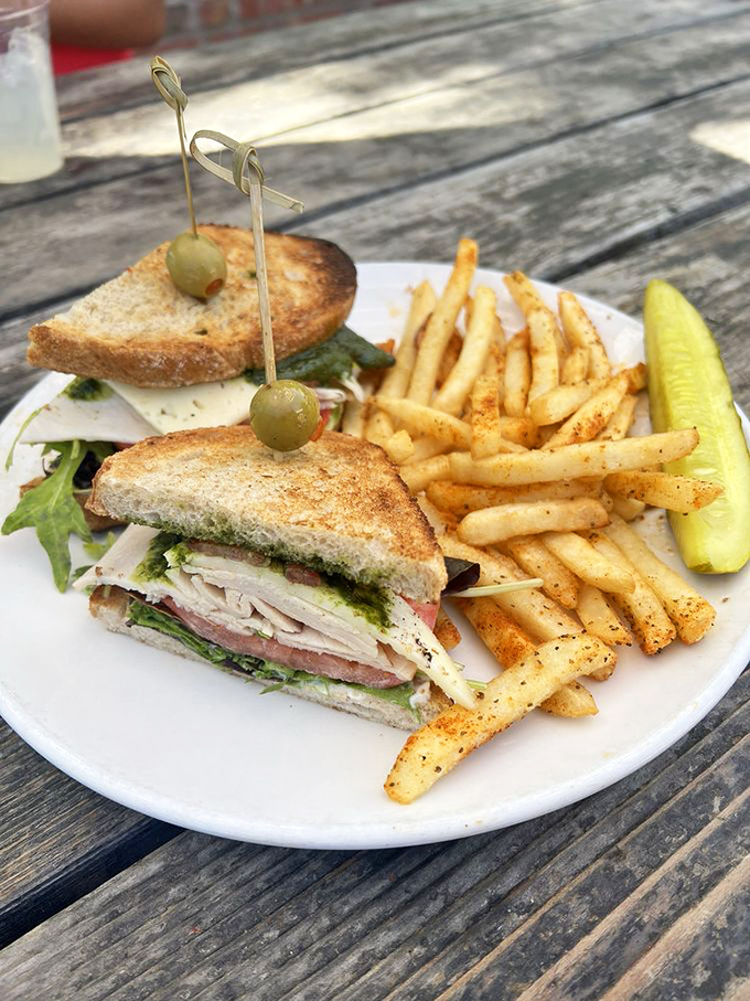 A sandwich that's dressed better for lunch than I am for dinner, complete with a fruit salad chaperone.