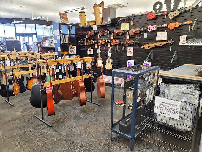 A guitarist's candy store where instruments of every shape and size hang like ripe fruit. Each one carries melodies waiting to be discovered.