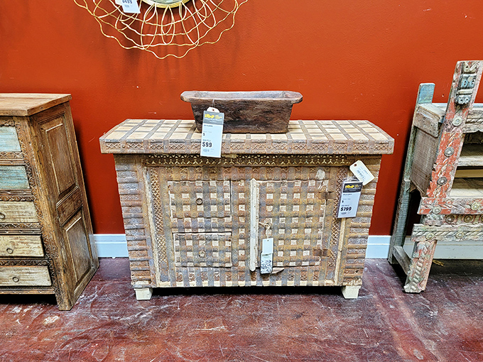 Rustic wooden cabinets with intricate lattice work that whisper "I have interesting stories to tell" against that bold terracotta wall.
