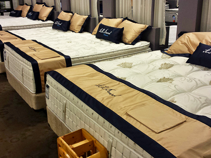 Luxury mattresses lined up like soldiers, each one promising to end your relationship with that 3 AM "why am I still awake" existential crisis.