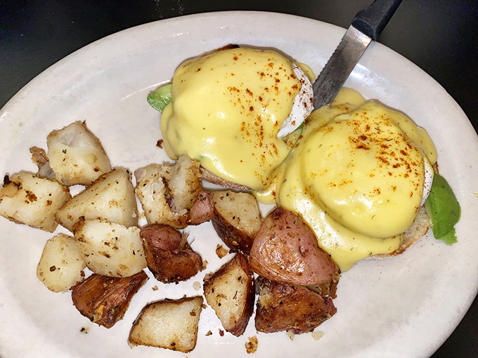 Eggs Benedict with avocado—where tradition meets California influence in the most delicious custody arrangement imaginable. Those potatoes are the perfect supporting cast.