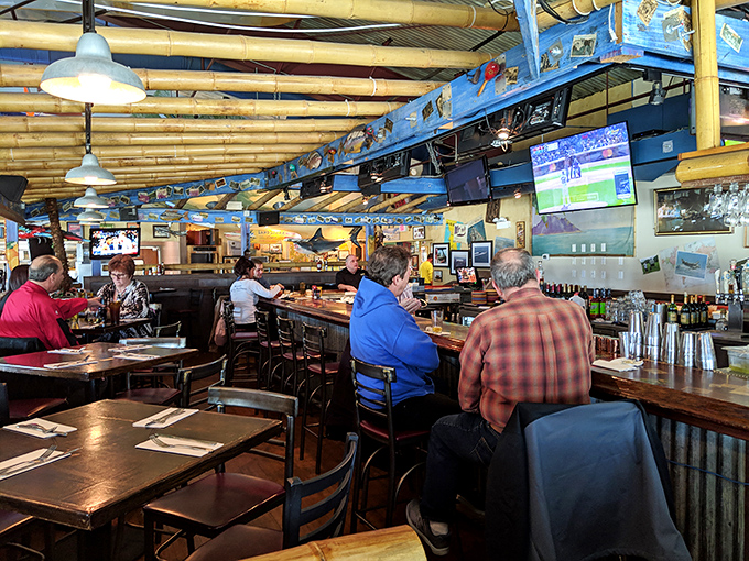 The bar area—where stories flow as freely as the drinks, under the watchful gaze of vintage aircraft models.