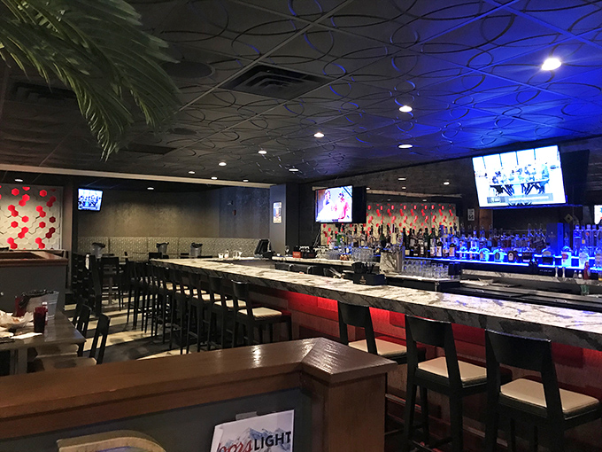The sleek bar area glows with blue light, promising craft cocktails worthy of accompanying the ocean's finest offerings.