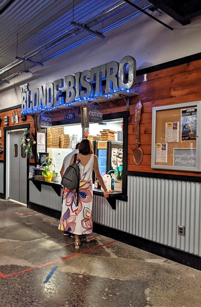 The Blonde Bistro's illuminated sign beckons like a lighthouse for the hungry. That rustic wood paneling hints at comfort food that satisfies after a day of treasure hunting.