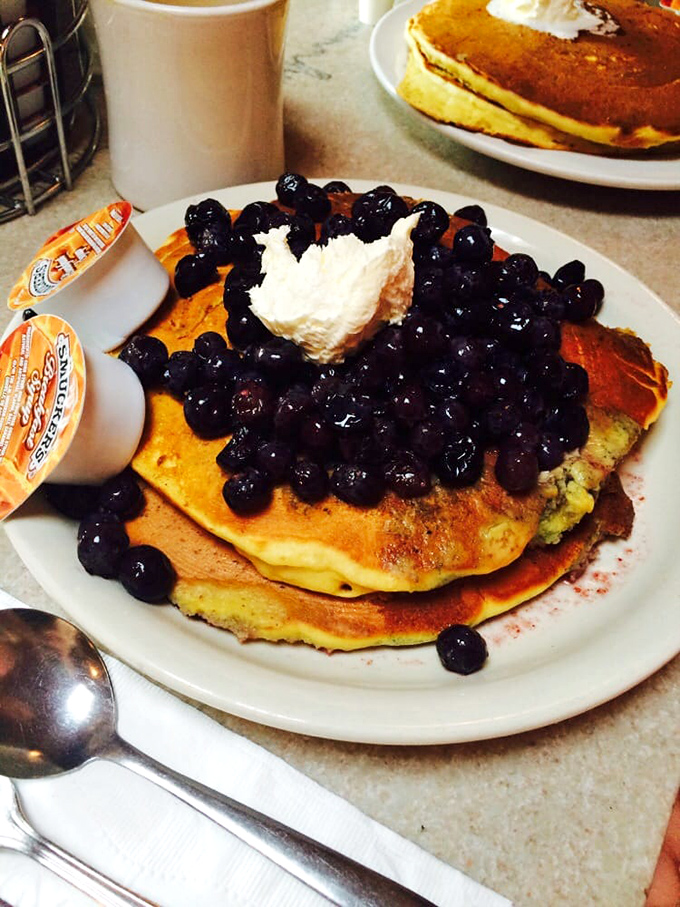 Blueberry pancakes that look like they're hosting a berry convention. The whipped cream referee makes sure all those blueberries play nice together.